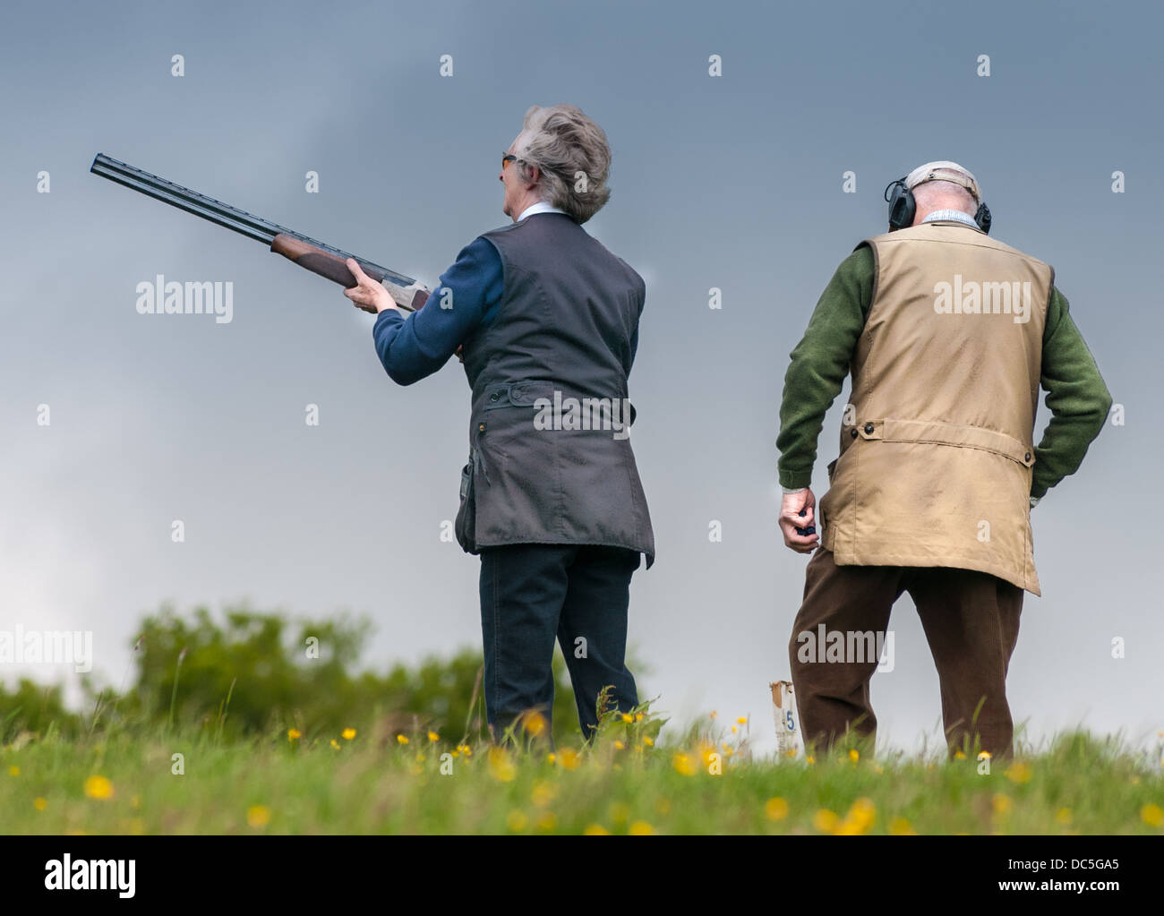 Lady shooting a shotgun at a simulated game and grouse clay shooting ...