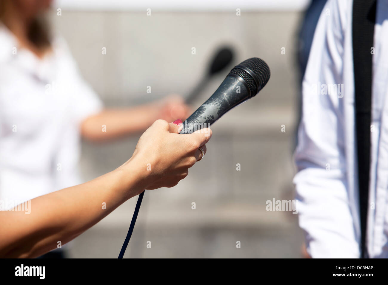 A journalist is making a interview with a microphone Stock Photo - Alamy
