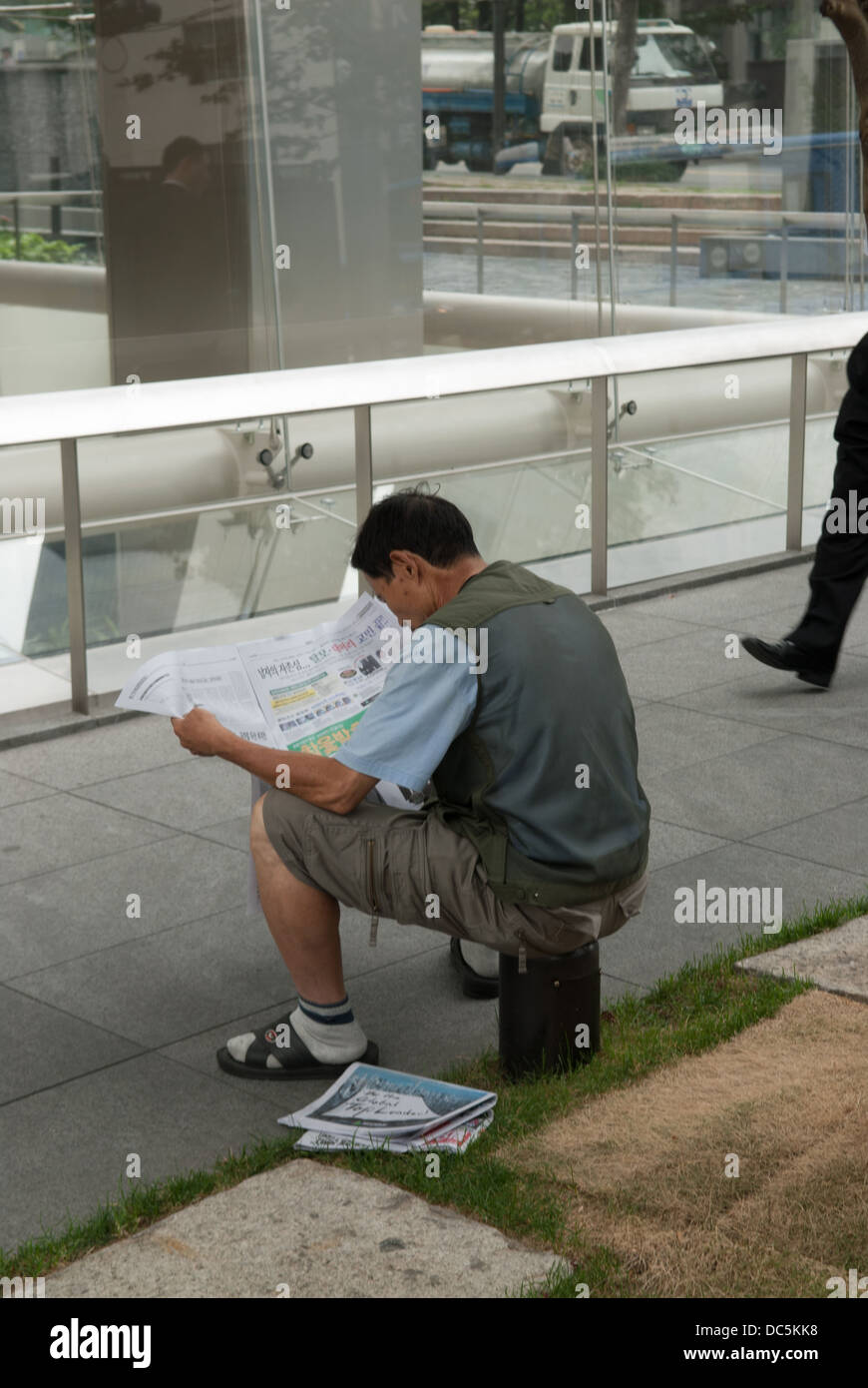 Man reading paper in Seoul business district, North Seoul, Korea Stock ...