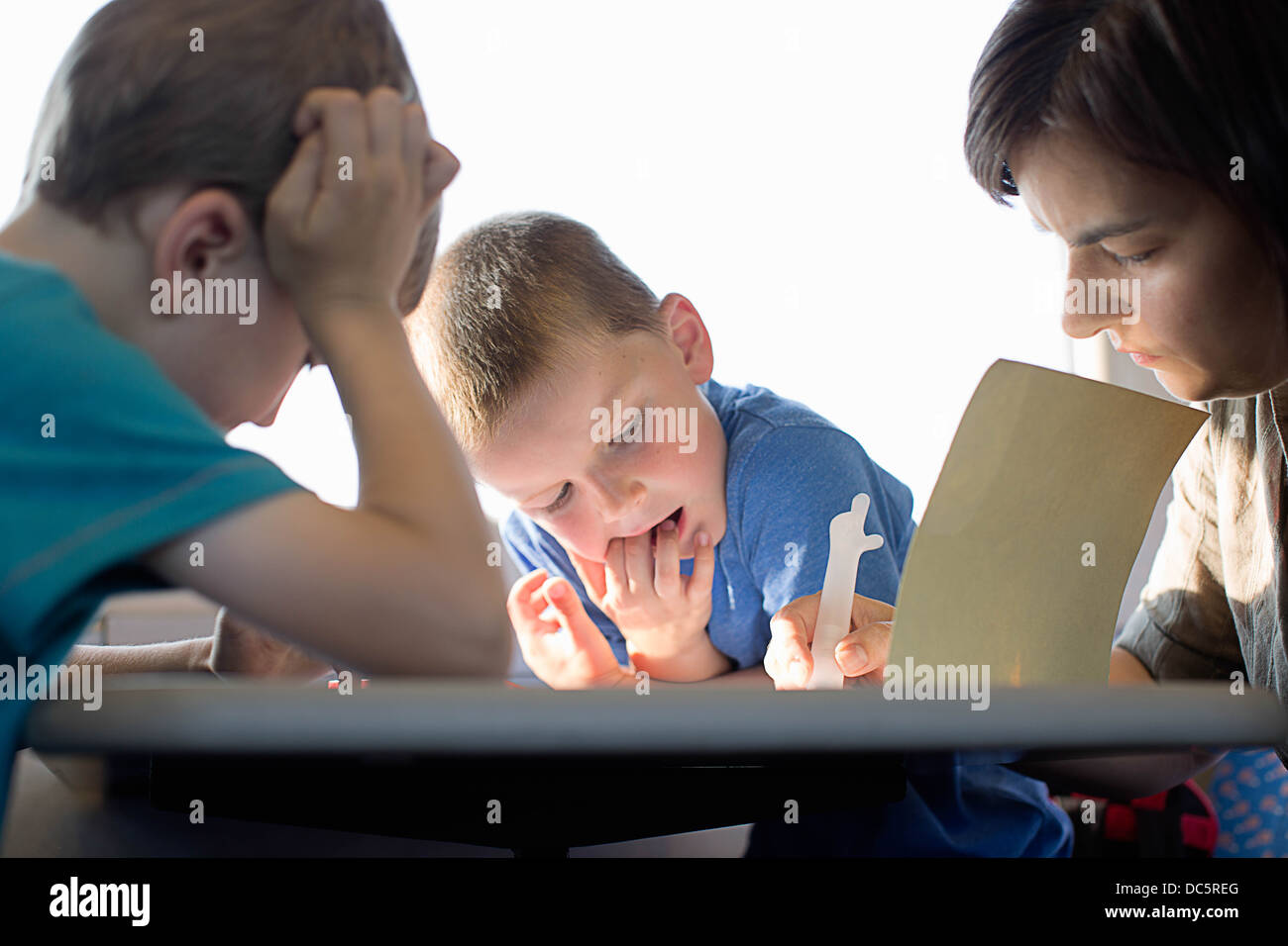 Family passing time with activities on train trip Stock Photo - Alamy
