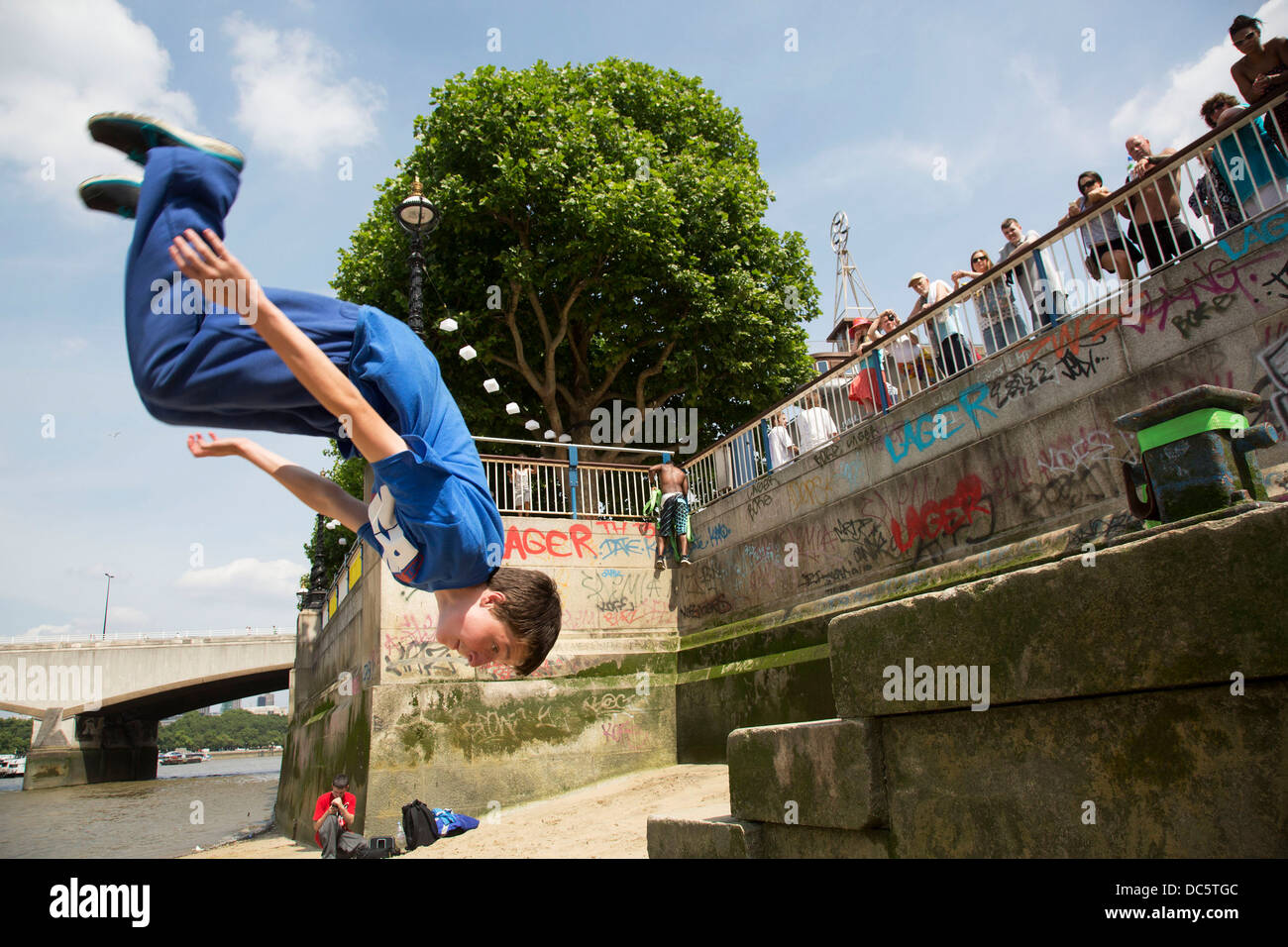 Young Parkour runners practice their moves on the river wall and steps ...