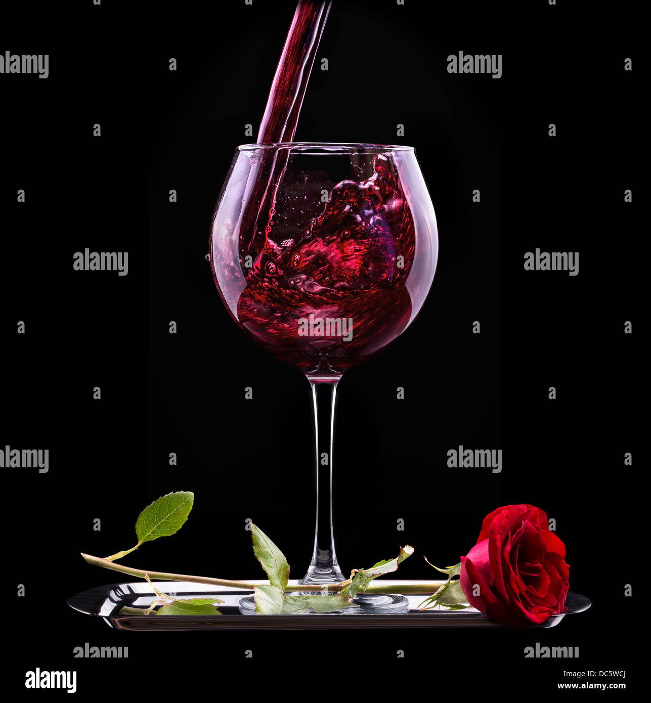 glass of red wine and red rose on black background Stock Photo - Alamy