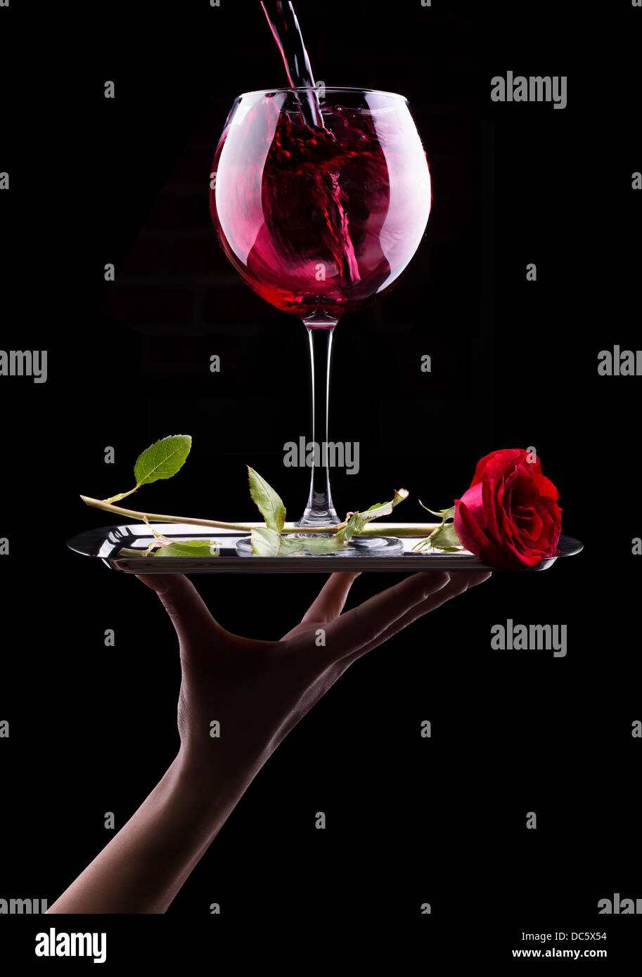 glass of red wine and red rose on black background Stock Photo - Alamy