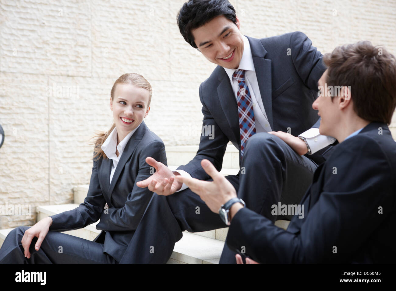 business people sitting on stairs chatting Stock Photo - Alamy