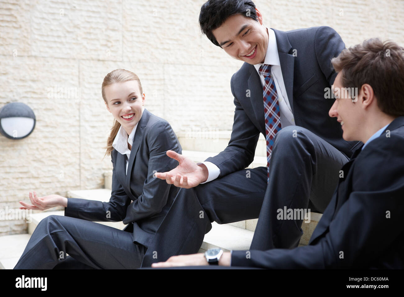 business people sitting on stairs chatting Stock Photo - Alamy
