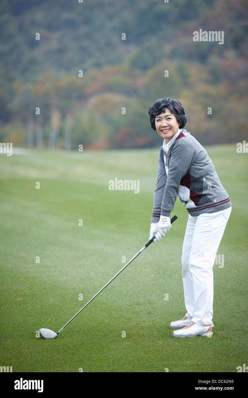 middle aged woman playing golf Stock Photo - Alamy