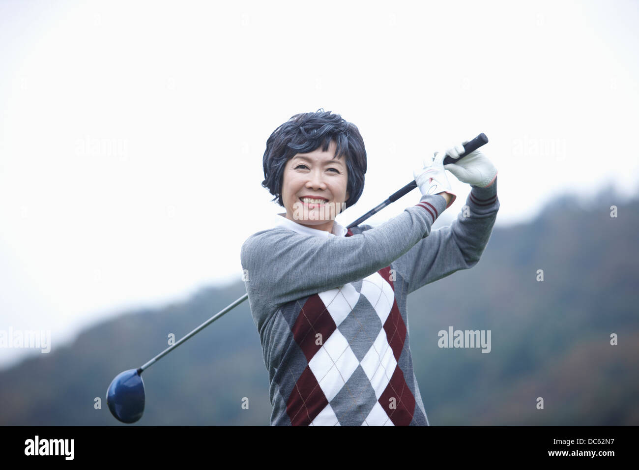middle aged woman playing golf Stock Photo - Alamy