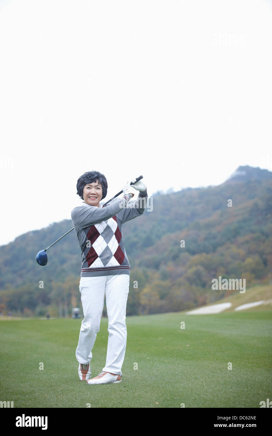 middle aged woman playing golf Stock Photo - Alamy