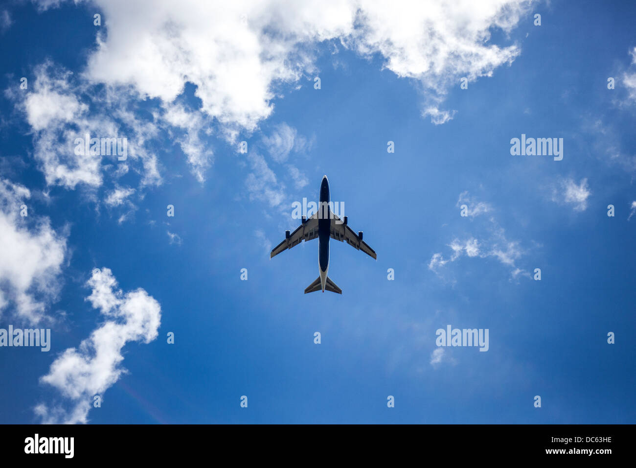 Airplane mid flight in blue sky Stock Photo - Alamy