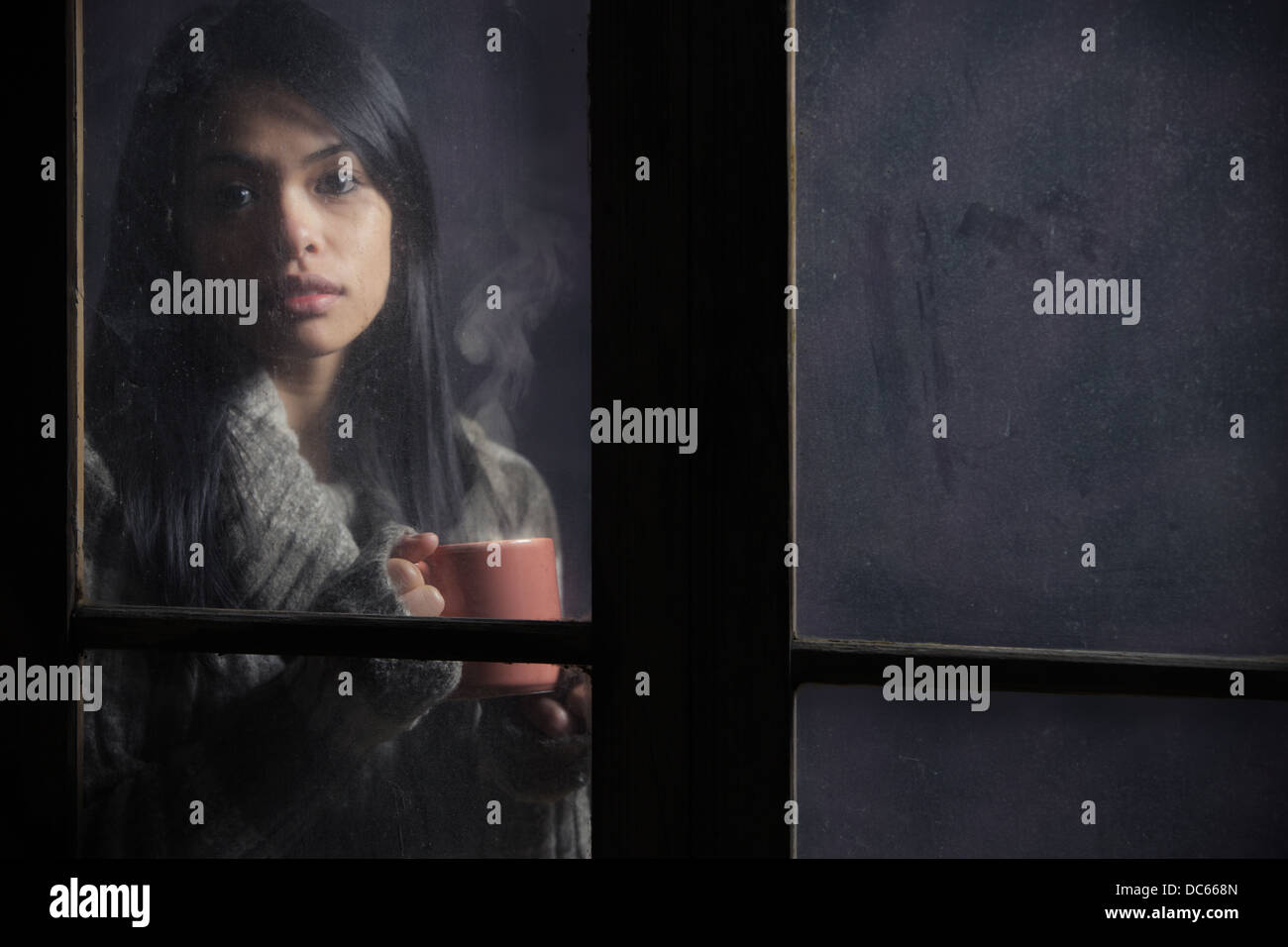 Portrait of a beautiful woman behind window with a cup of coffee Stock ...
