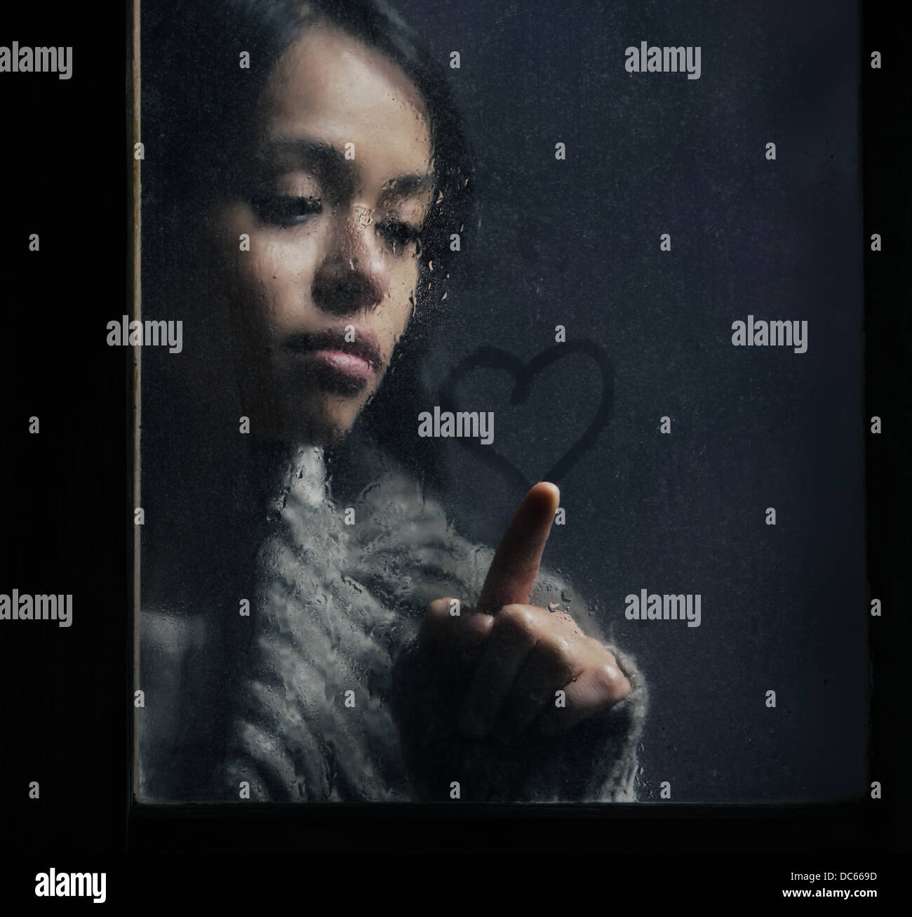 Beautiful girl drawing heart on wet window Stock Photo - Alamy