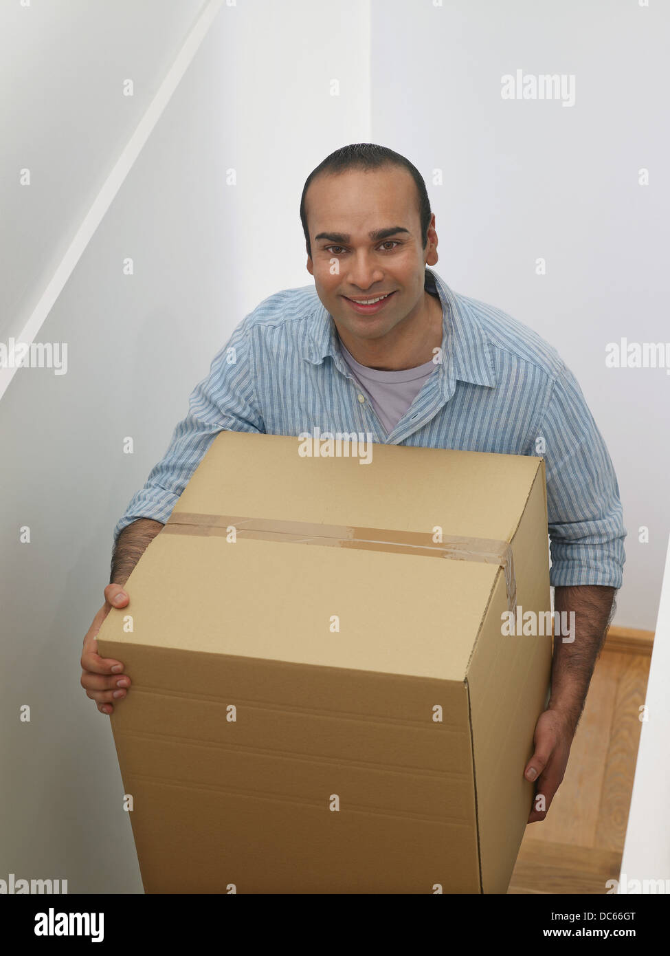 man carrying box into new home Stock Photo - Alamy