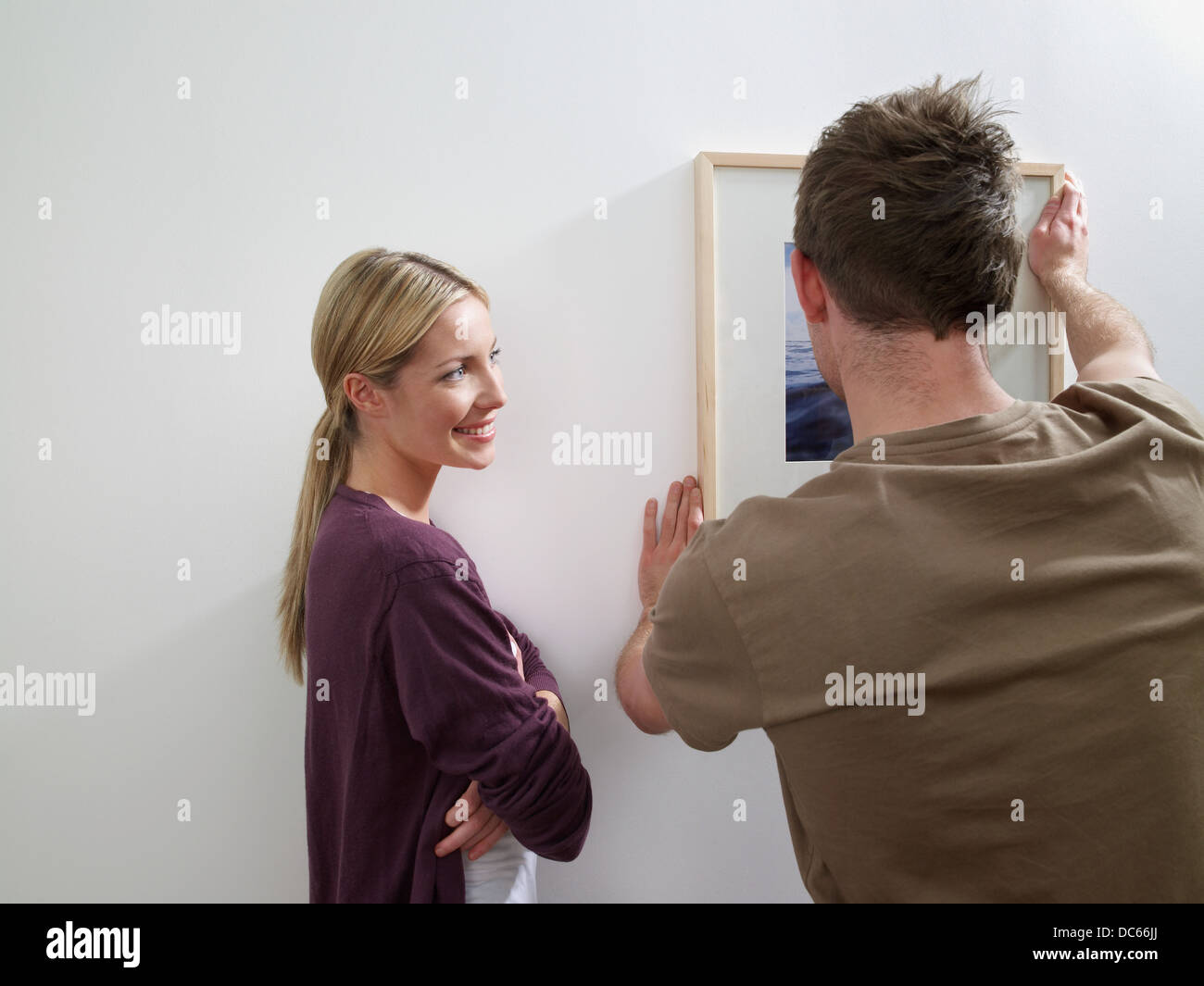 Moving house couple hanging picture hi-res stock photography and images ...
