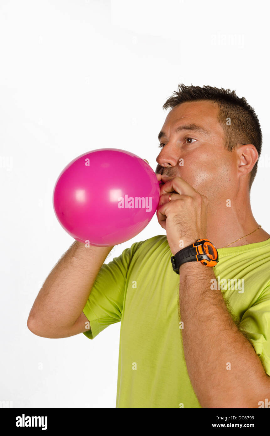 Guy blowing up a pink balloon, isolated on white Stock Photo - Alamy
