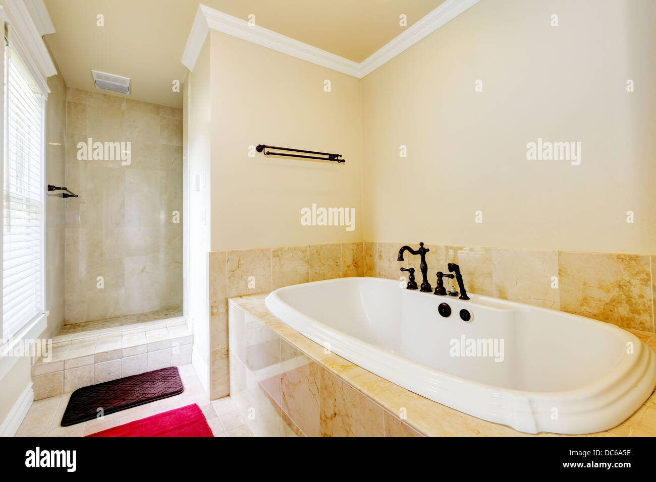 Nice empty bathroom with large white tub and shower Stock Photo - Alamy