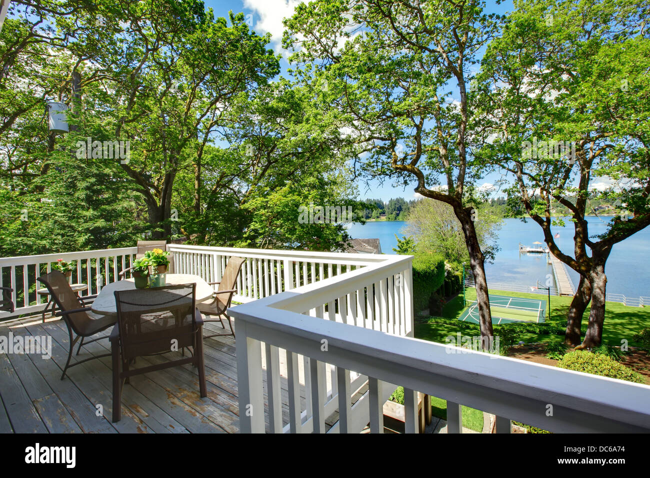 Large balcony home exterior with table and chairs, lake view Stock ...