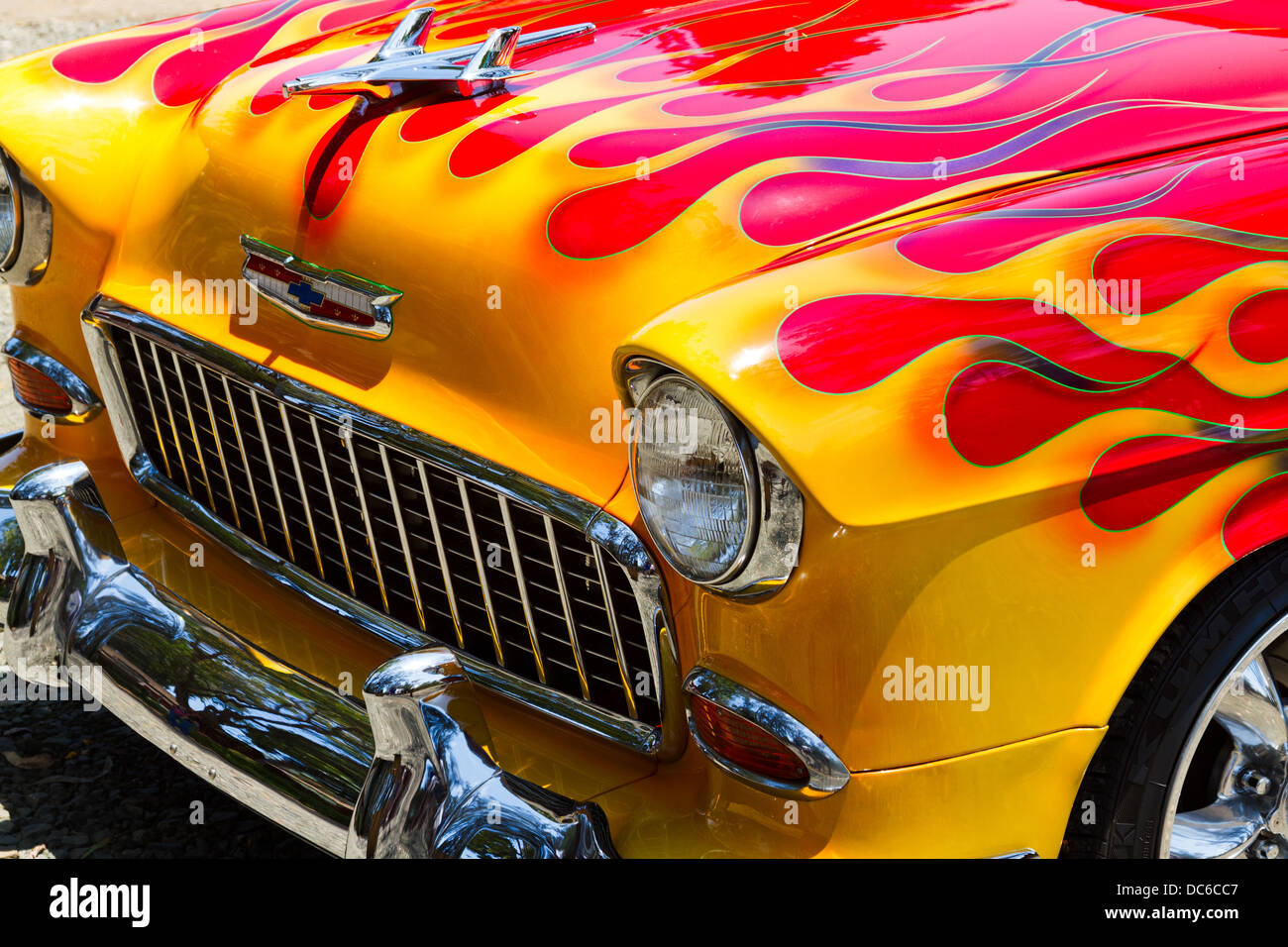Closeup front 3/4 view of a 1955 bright yellow Chevrolet painted with ...