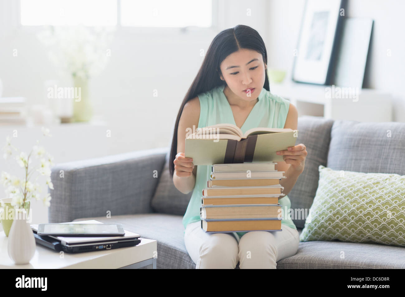 Woman with stack of books at home Stock Photo - Alamy