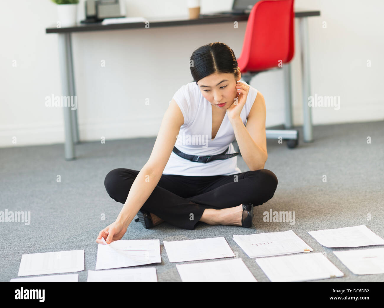 Businesswoman organizing paperwork on floor Stock Photo - Alamy