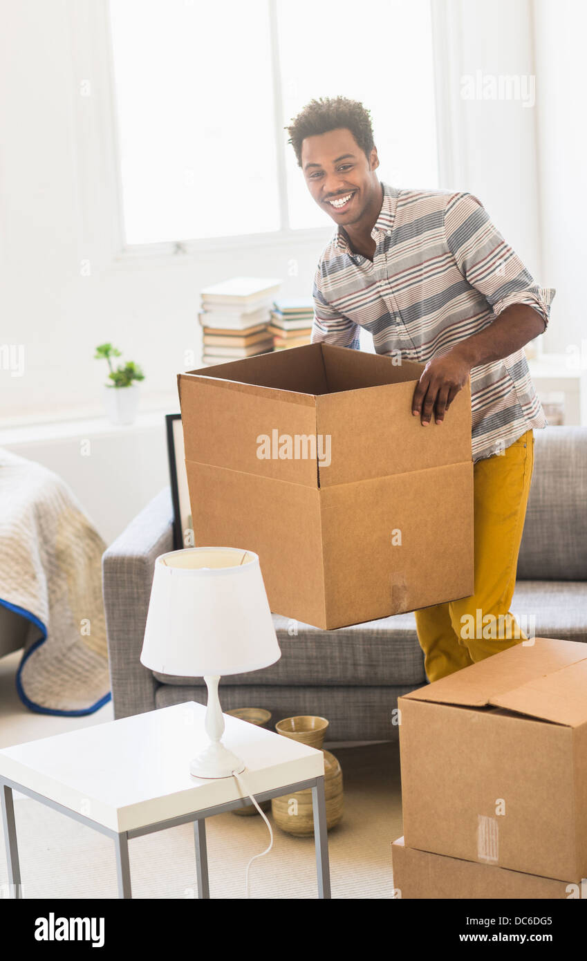 Man holding cardboard box in living room Stock Photo - Alamy