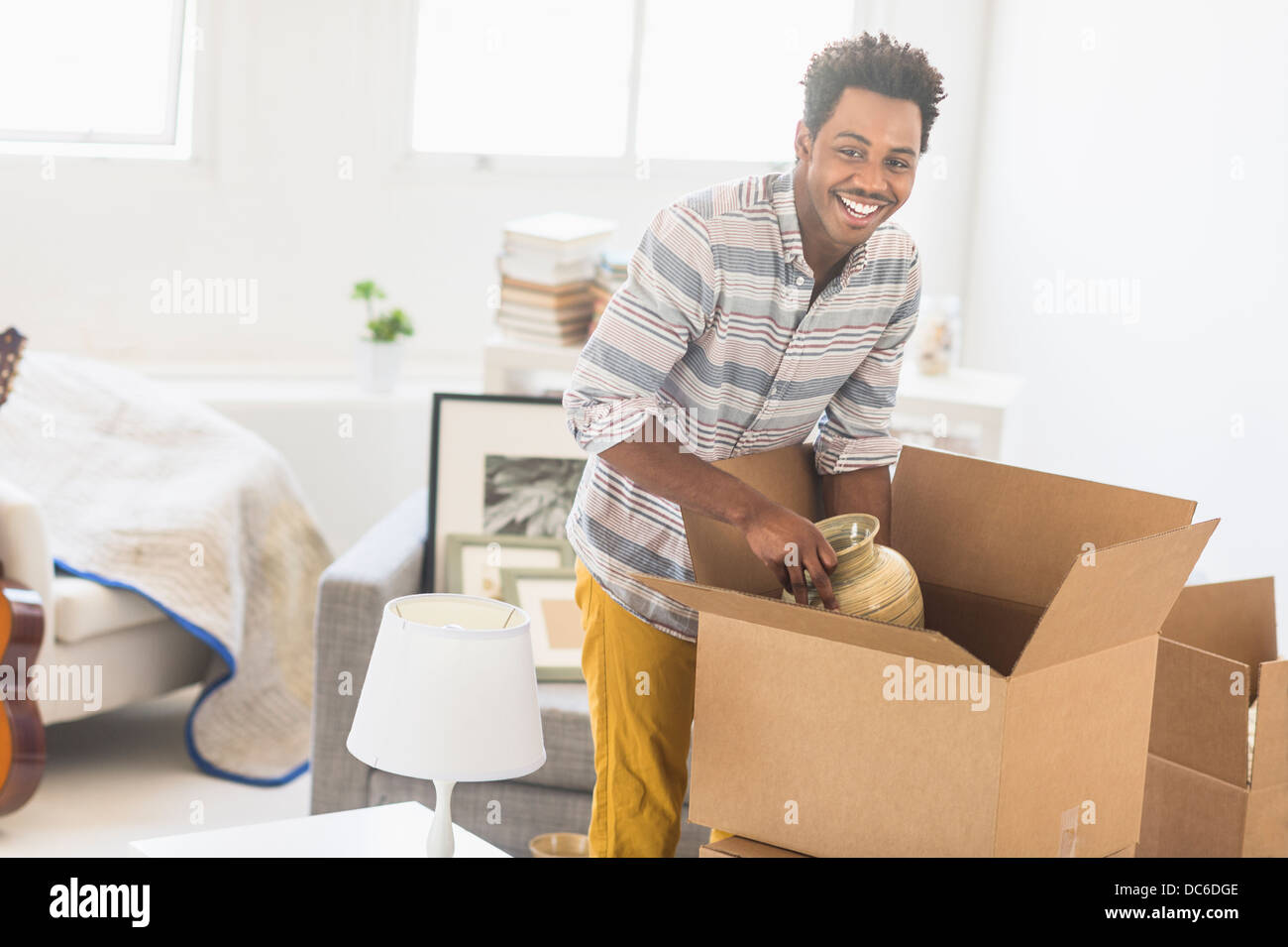 Man packing decors into cardboard box Stock Photo - Alamy