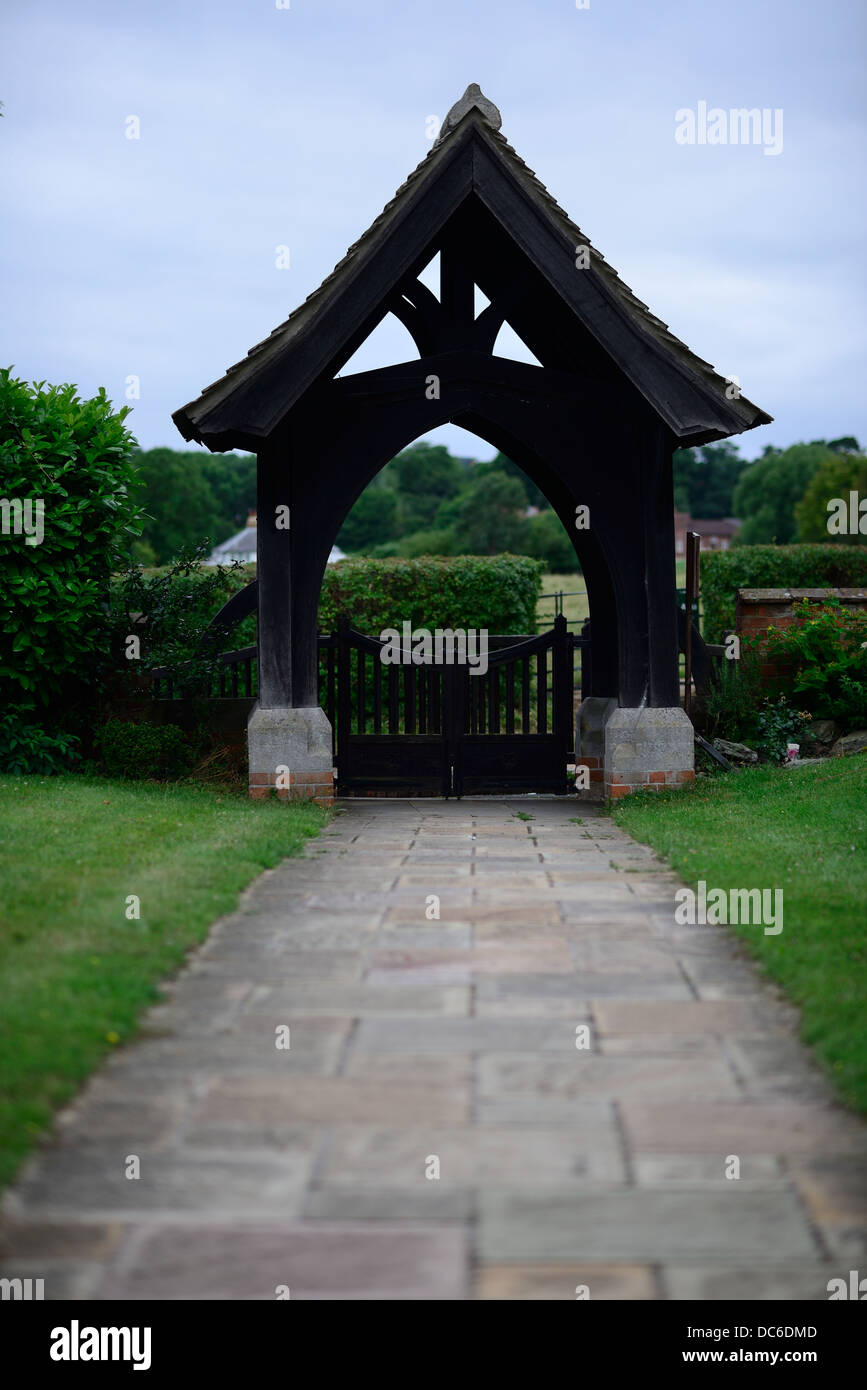 A path in the grounds of a church leading to the wooden entrance gate ...