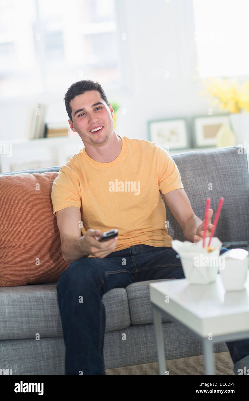 Man eating take out meal and watching television Stock Photo - Alamy