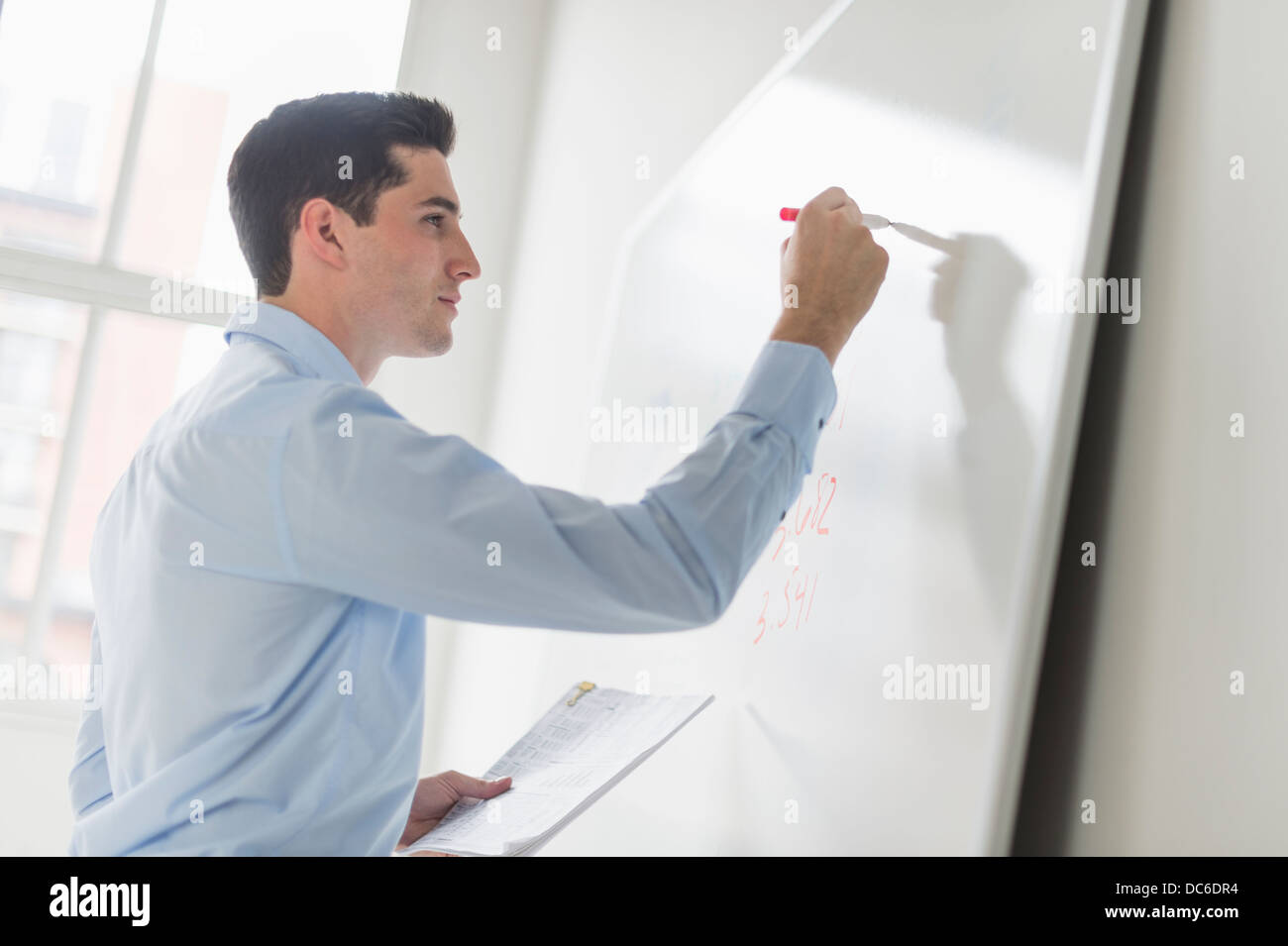 Businessman writing on whiteboard Stock Photo - Alamy