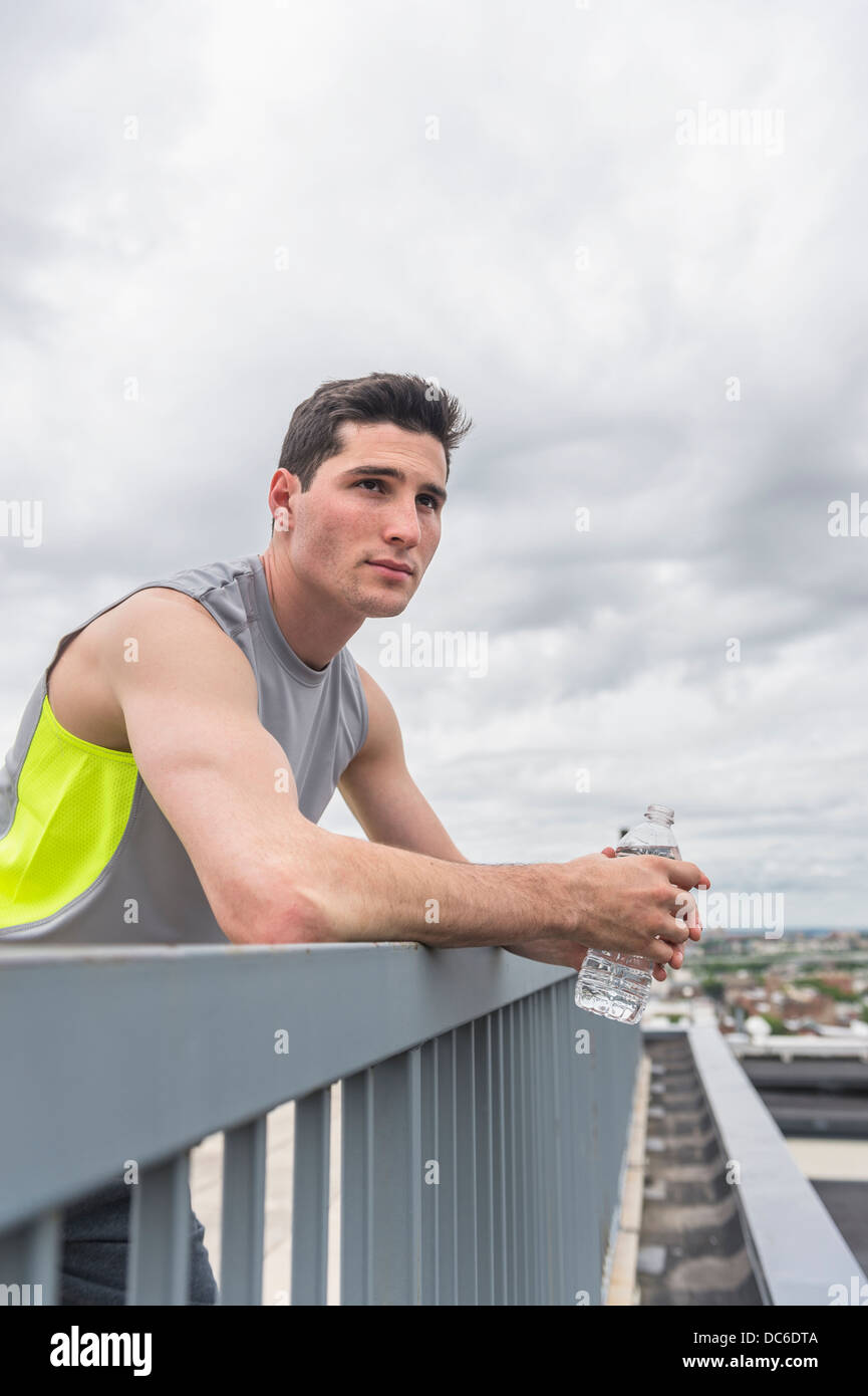 Athlete leaning against railing Stock Photo - Alamy