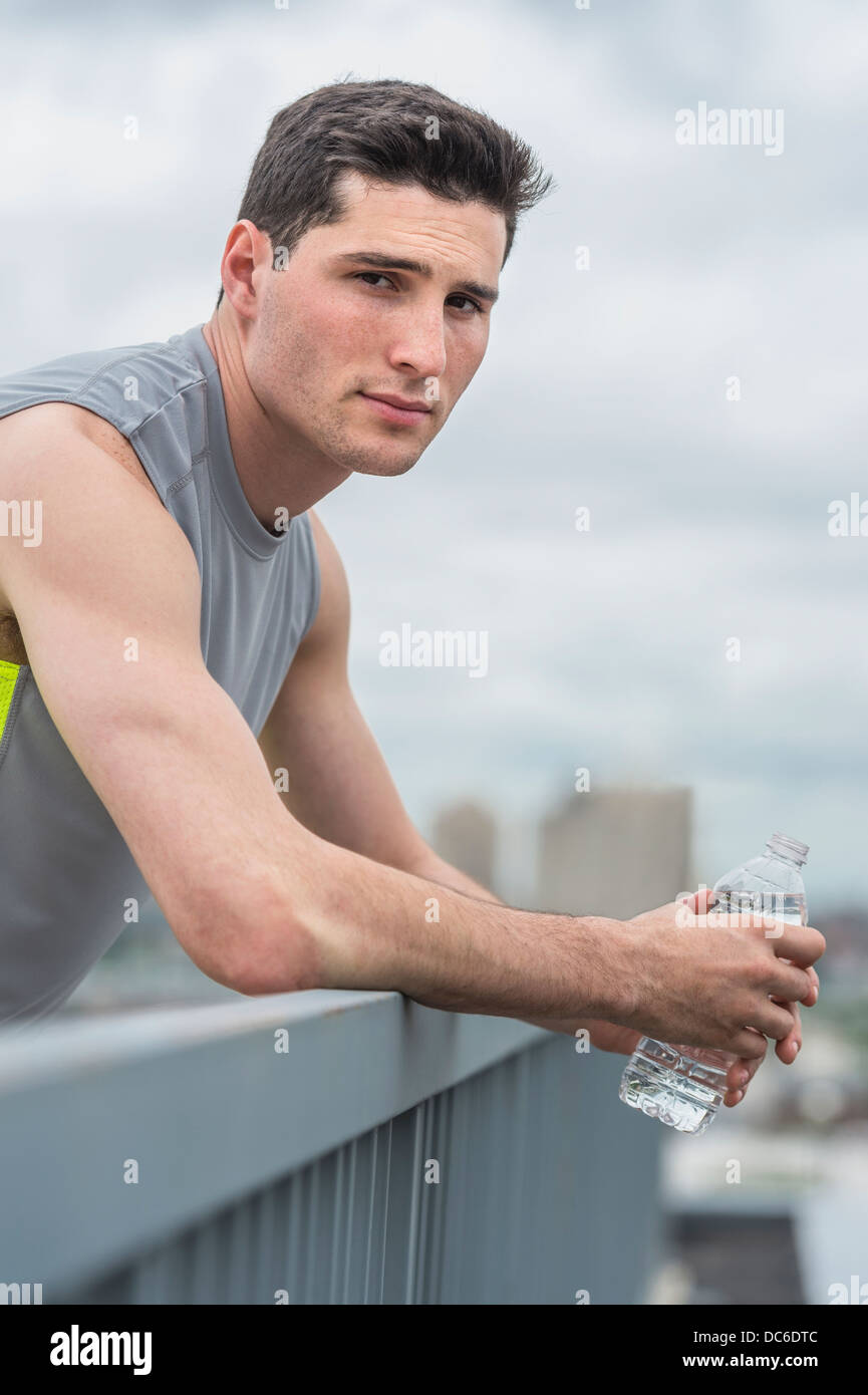 Athlete leaning against railing Stock Photo - Alamy
