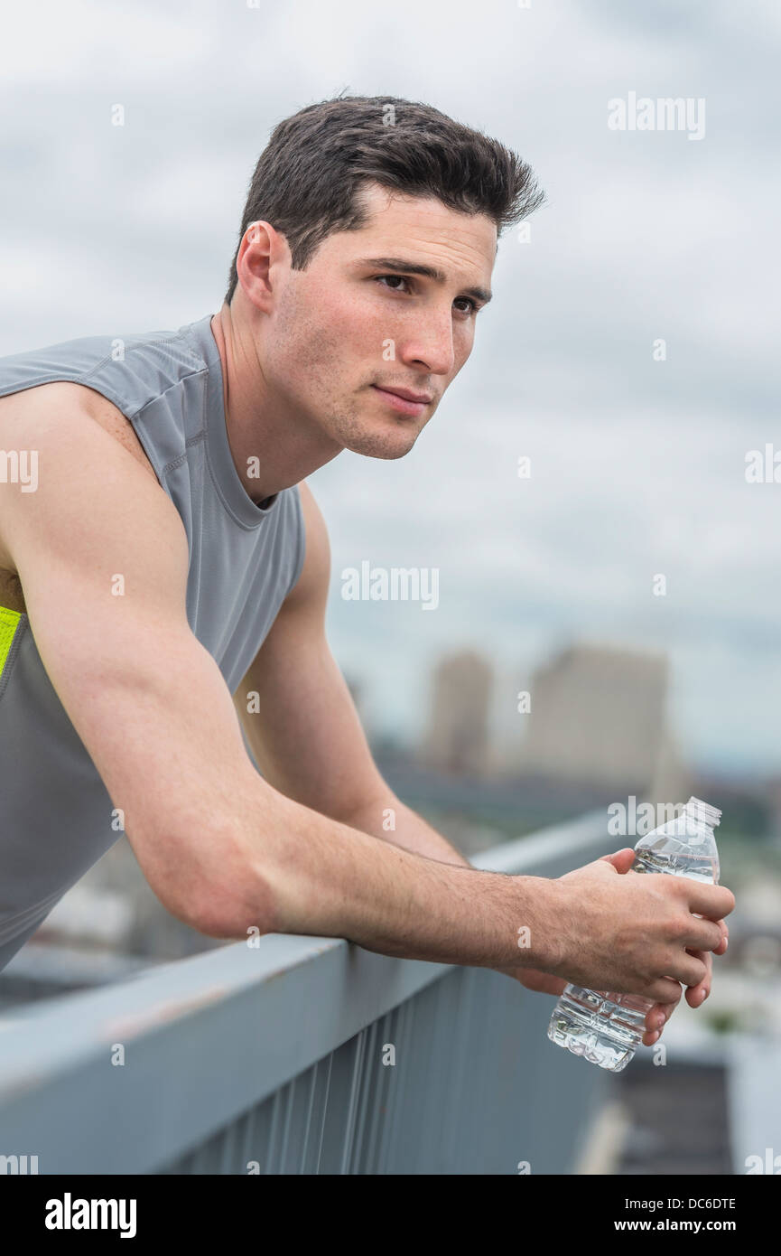 Athlete leaning against railing Stock Photo - Alamy