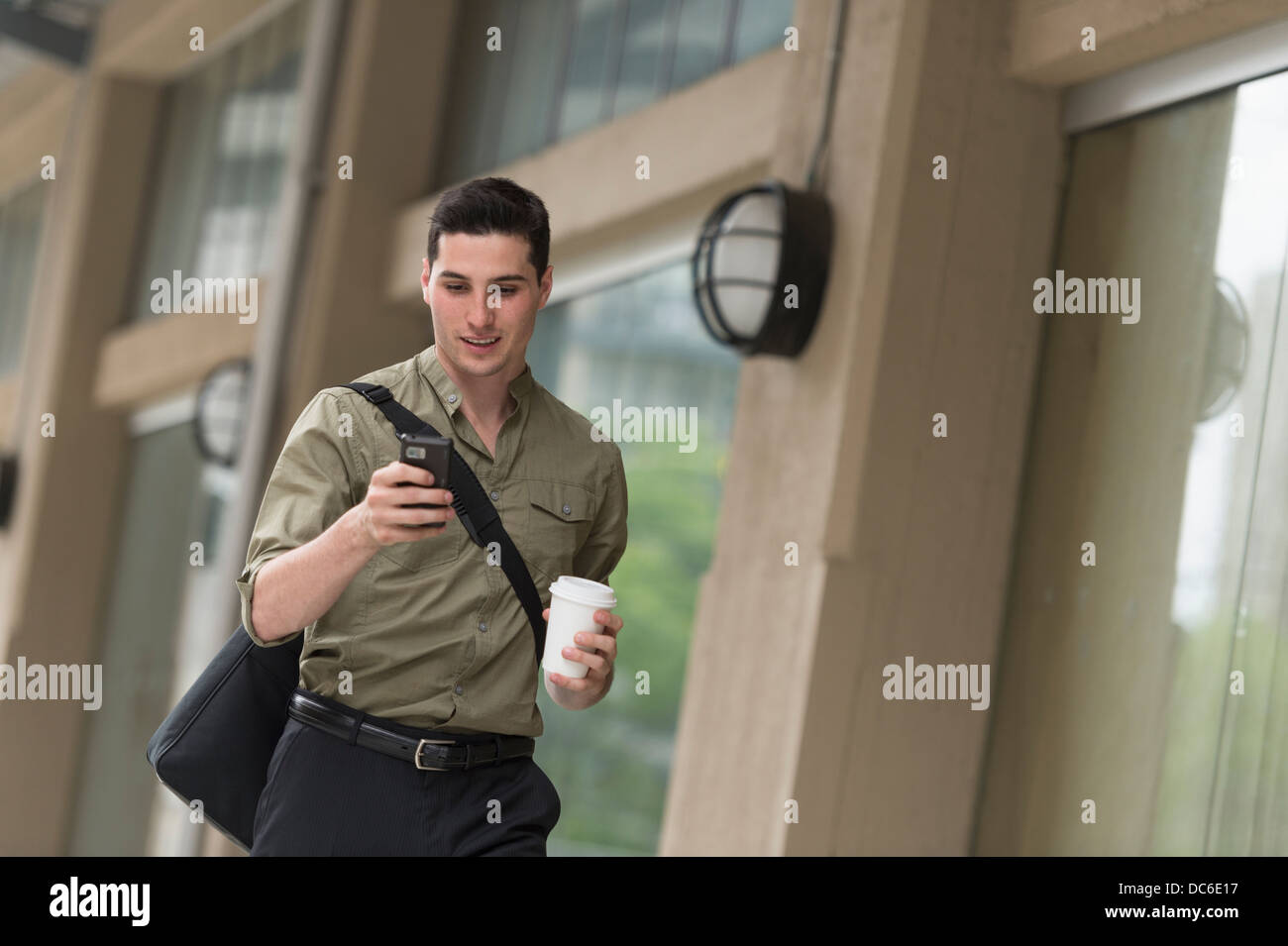 Man walking on street and text messaging Stock Photo - Alamy