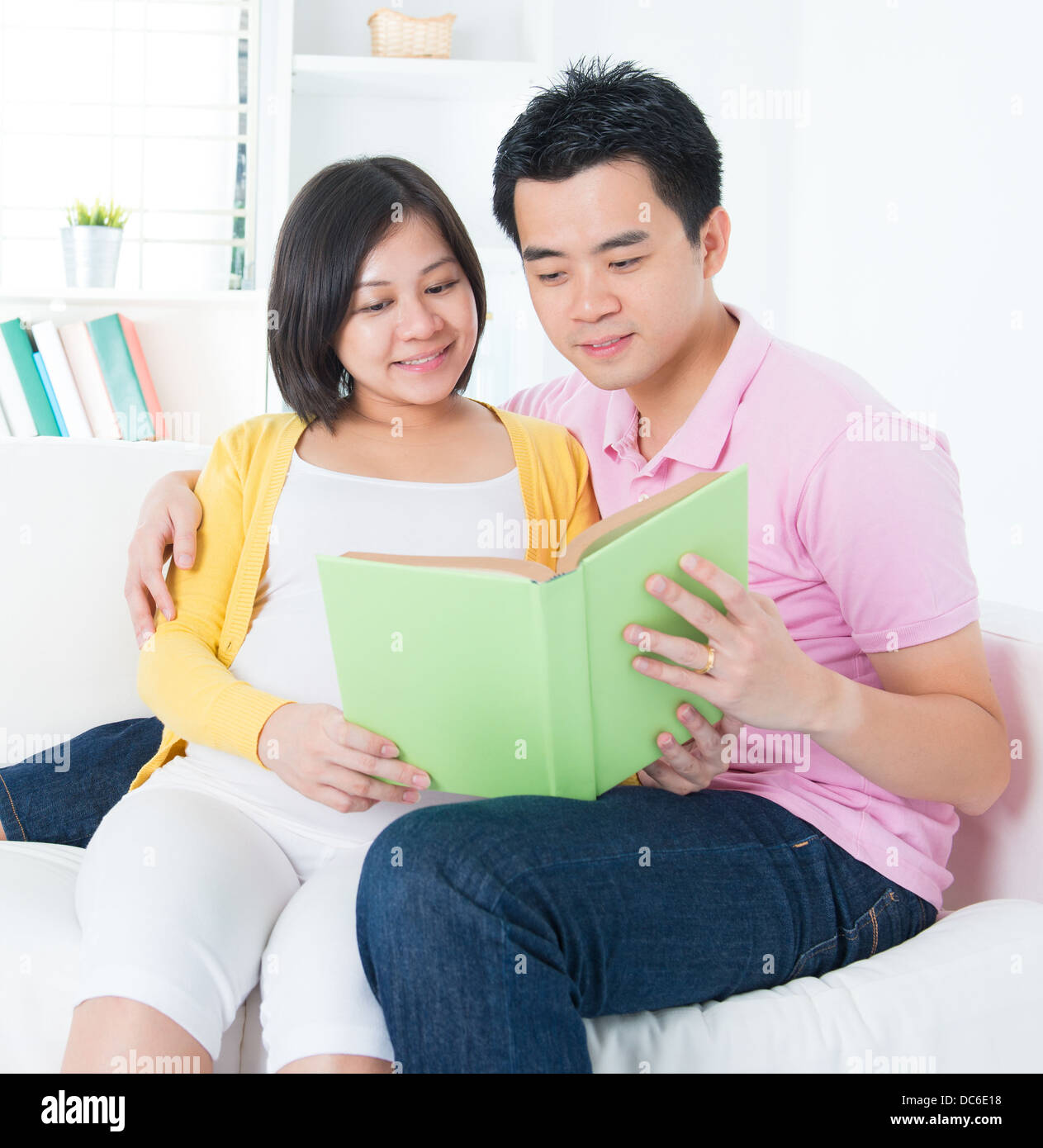 Asian couple reading book together Stock Photo - Alamy