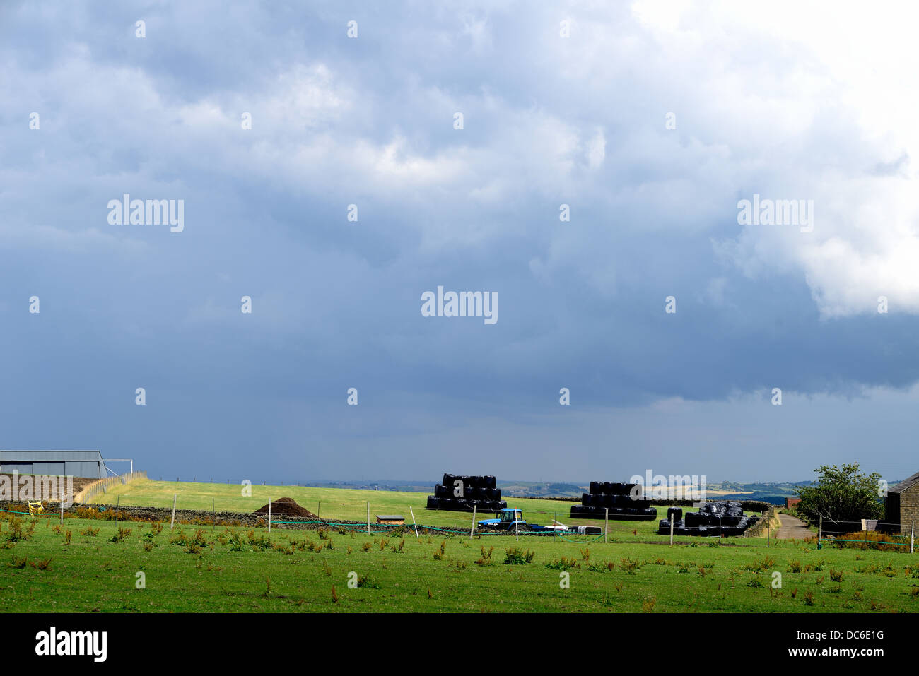 A landscape scene of a farm making bails of hay Stock Photo - Alamy