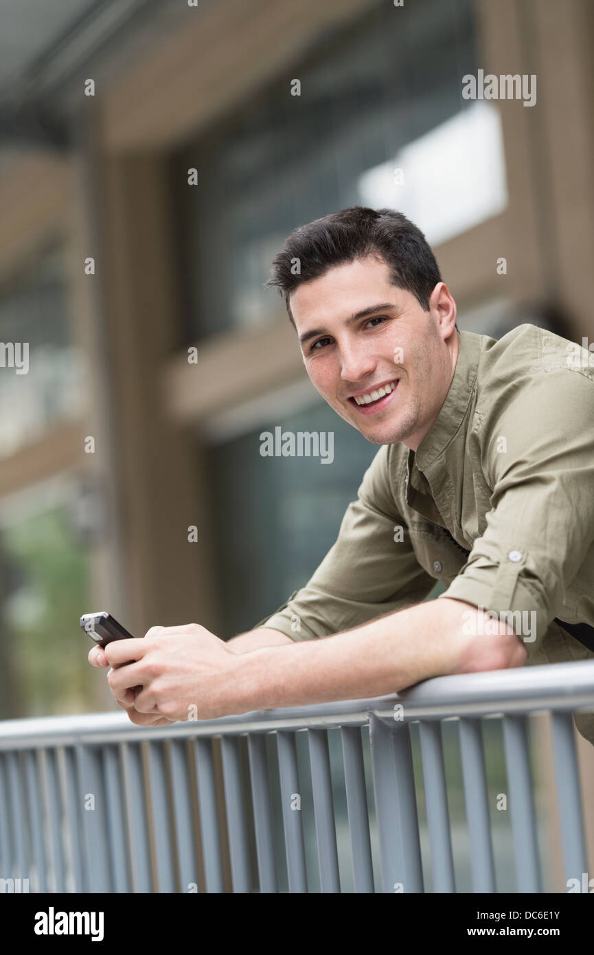 Black man on his phone smiling and texting hi-res stock photography and ...