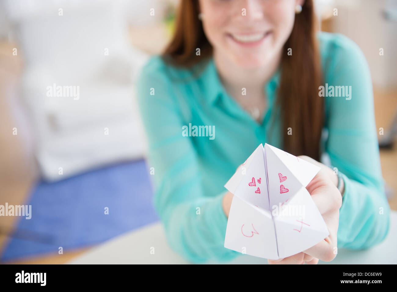 Teenage girl (14-15) showing origami Stock Photo - Alamy