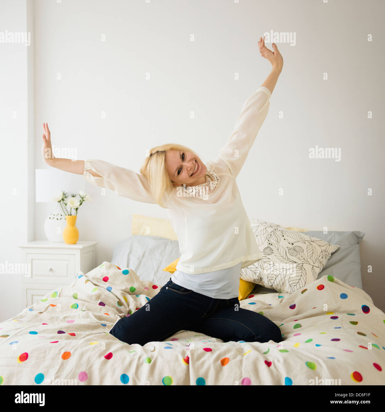 Young woman stretching in bed Stock Photo - Alamy