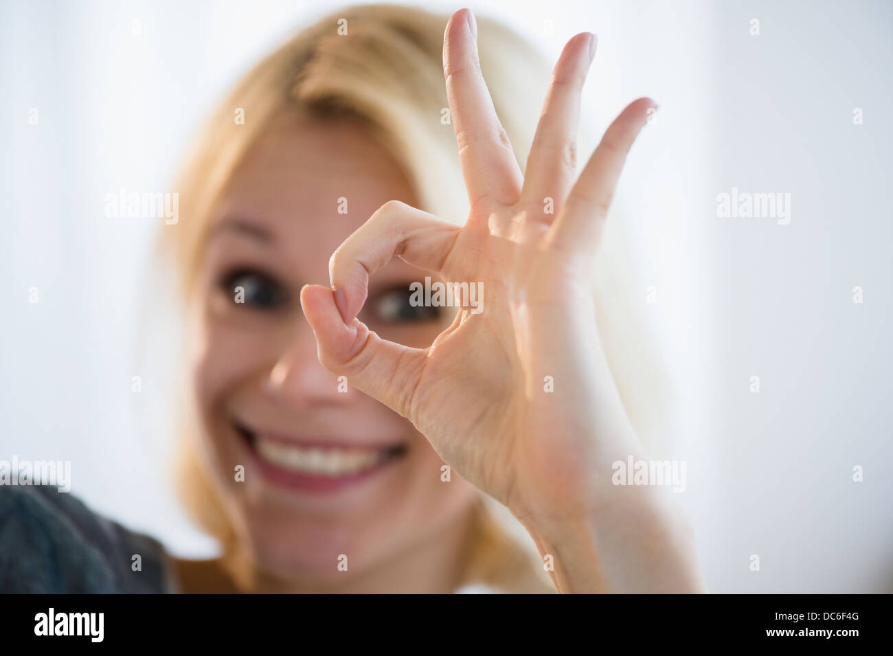 Young woman showing ok sign Stock Photo - Alamy