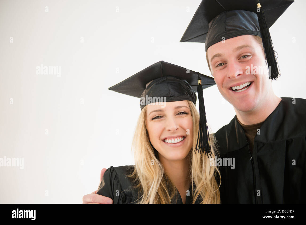 Couple of friends in graduation gowns Stock Photo - Alamy