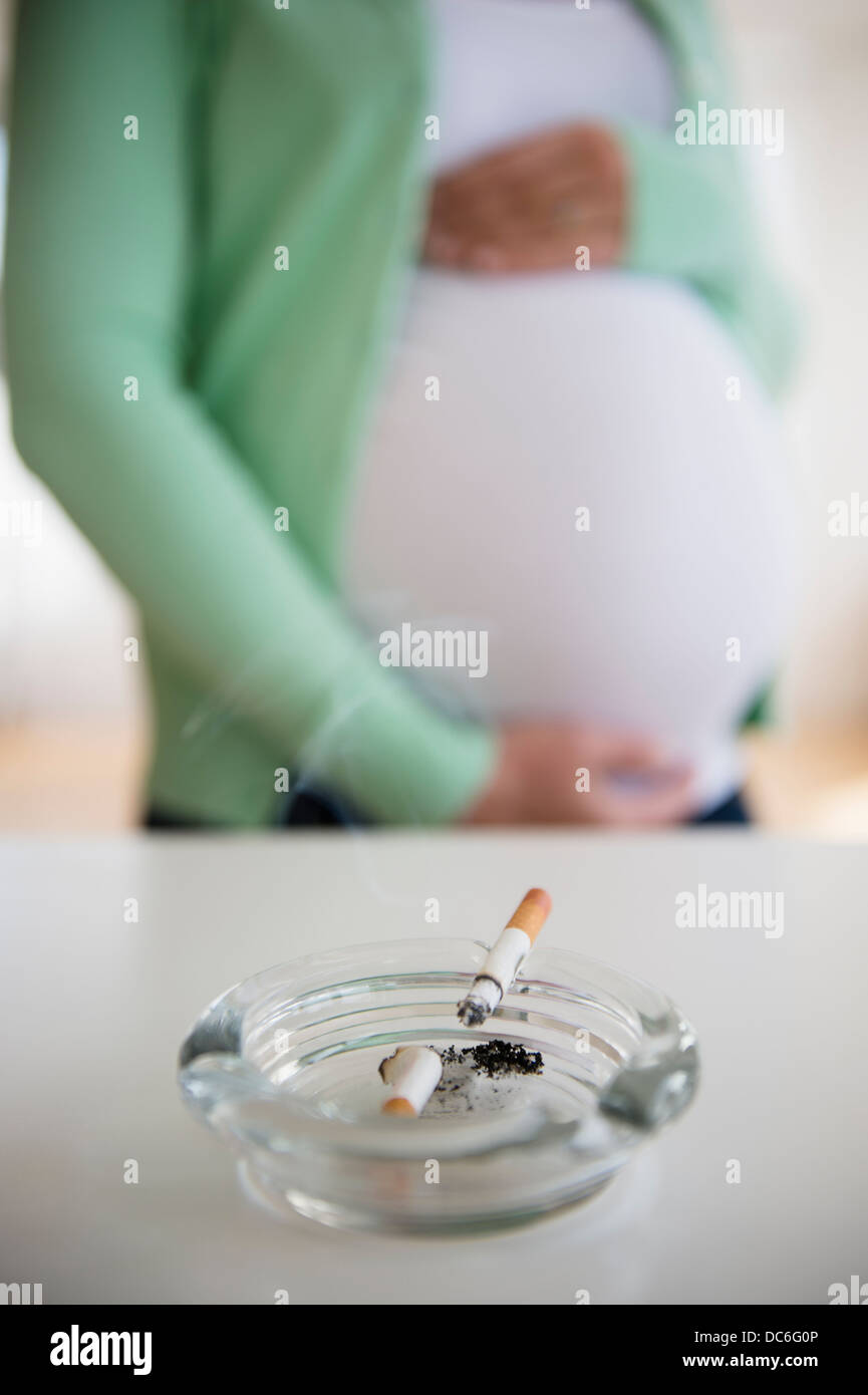 Mid section of pregnant woman, ashtray and cigarette in front Stock ...