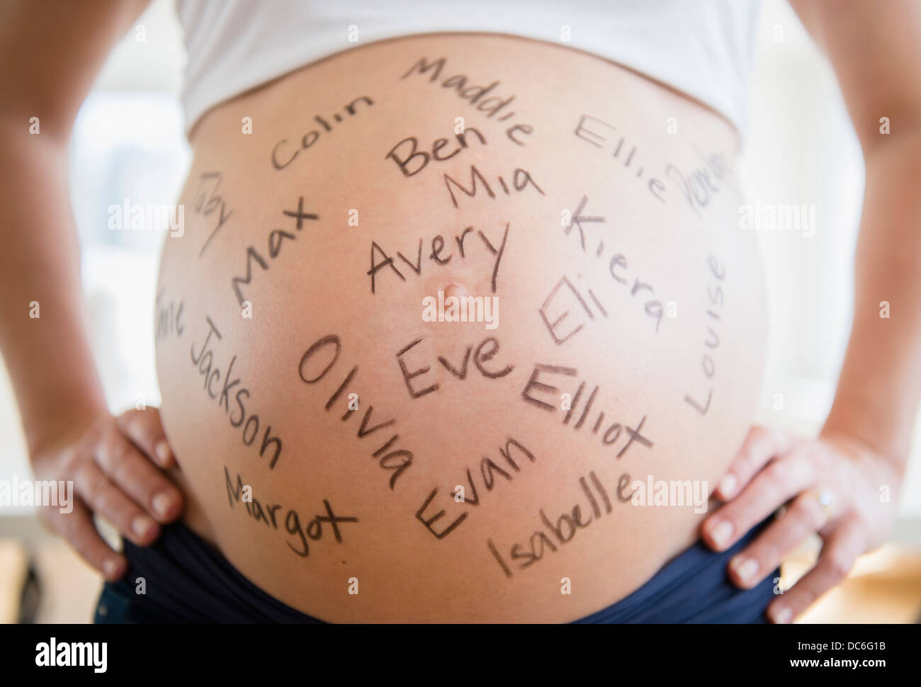 Mid section of pregnant woman with names written on her belly Stock ...