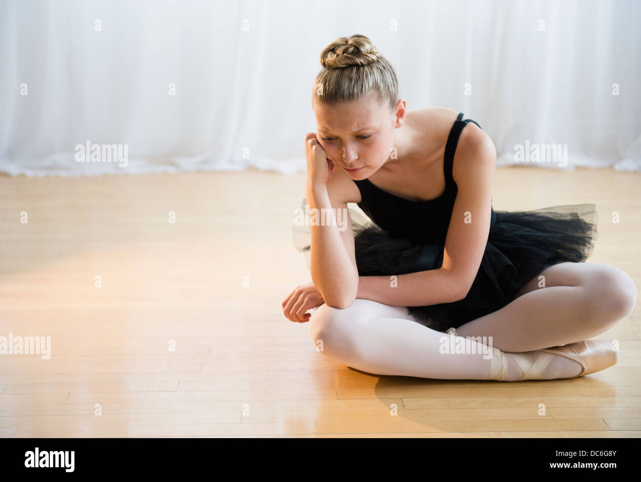 Portrait of tired teenage (16-17) ballet dancer sitting on floor Stock ...