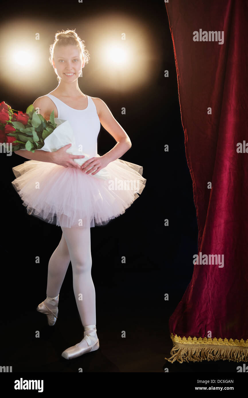 Teenage (16-17) ballerina on stage holding bunch of roses Stock Photo ...