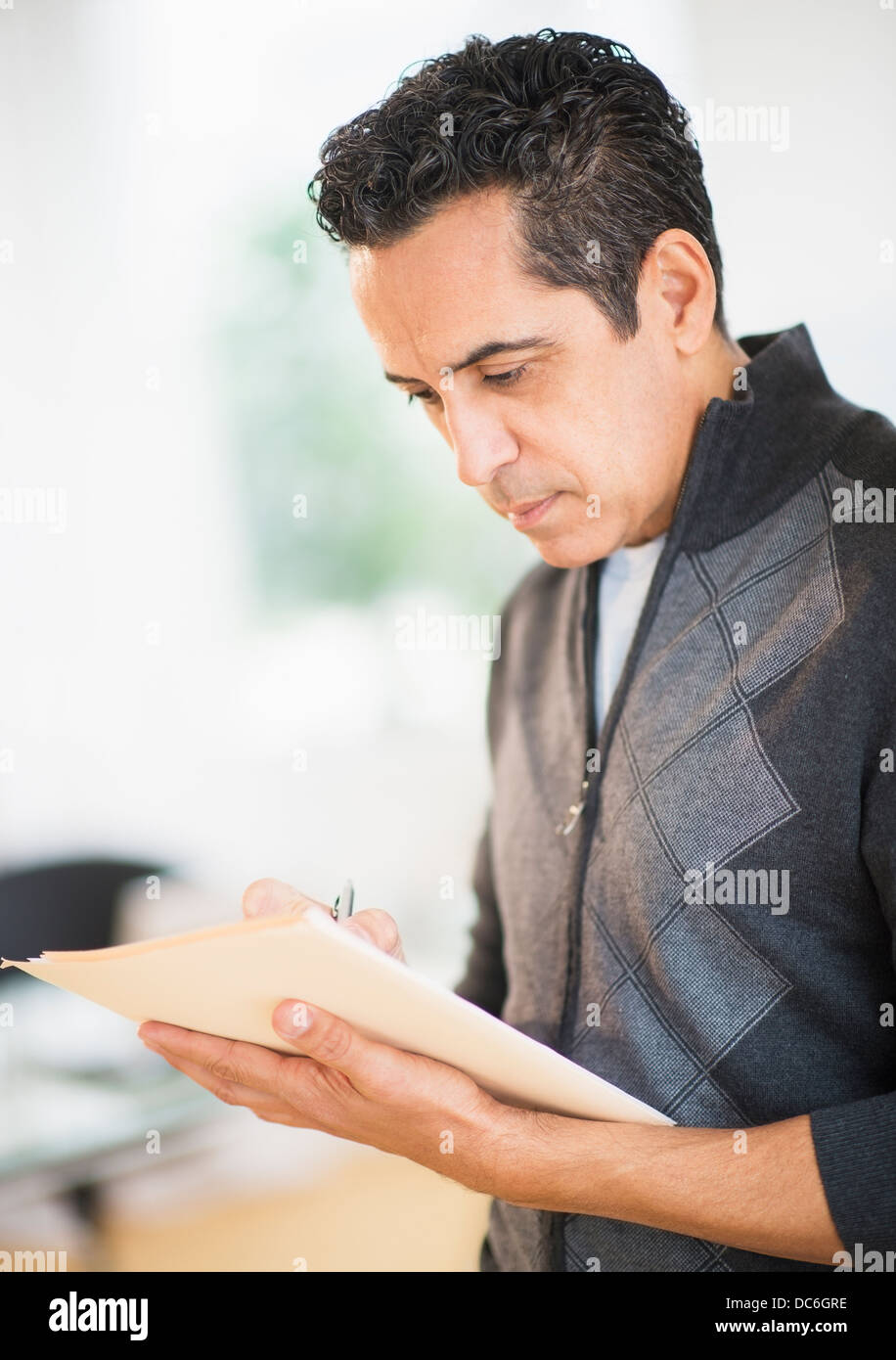 Portrait of man holding documents and writing Stock Photo - Alamy