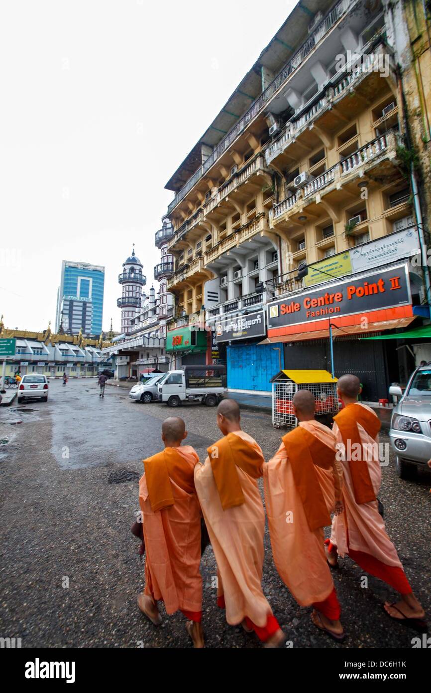 Monks walk past a house built in colonial architecture in Rangoon ...