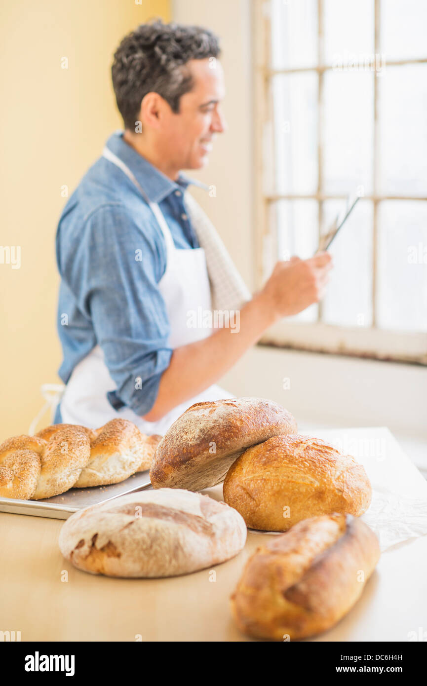 Side view of baker using digital tablet Stock Photo - Alamy
