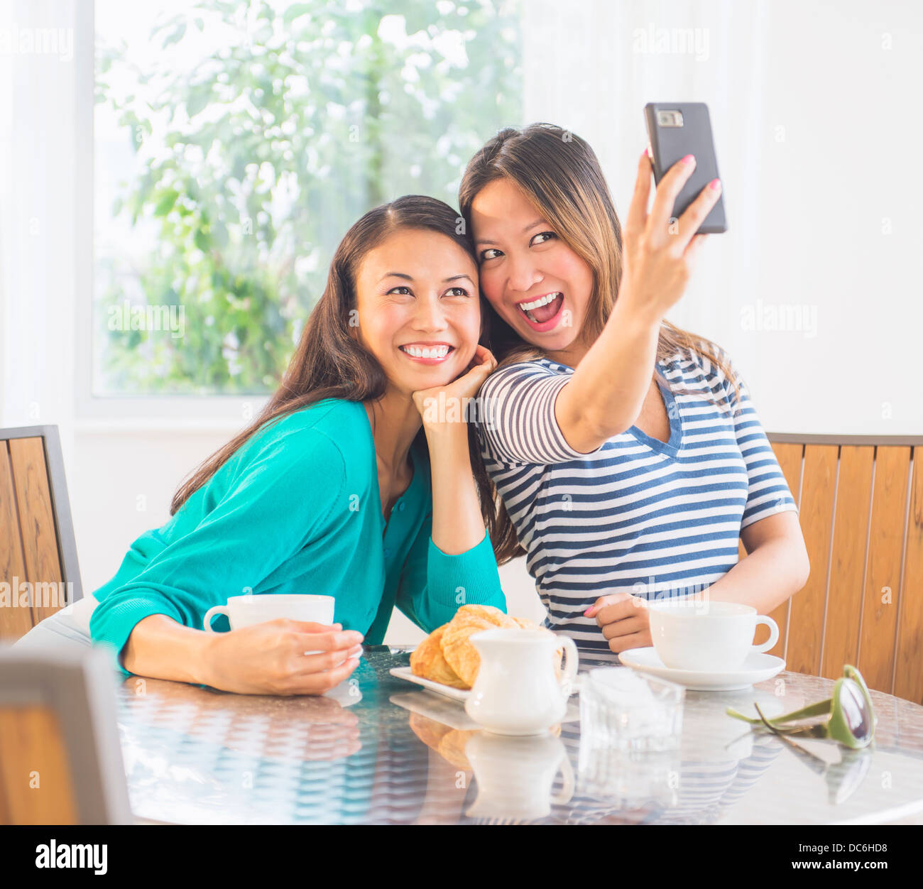 Two women using mobile phone Stock Photo - Alamy