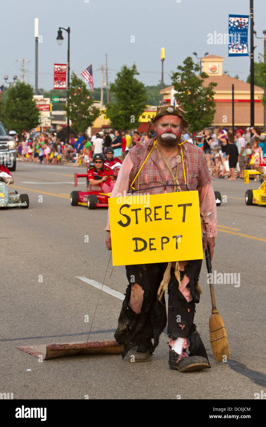Man dresses as a hobo cleaning the streets in a parade Stock Photo - Alamy