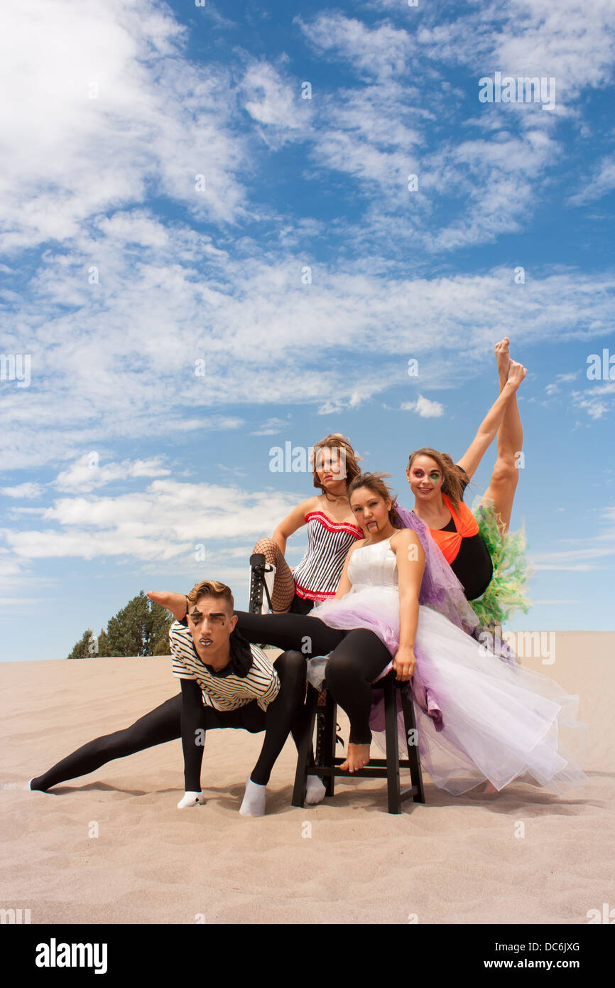 A young circus troupe pose supporting one another in the desert sand ...
