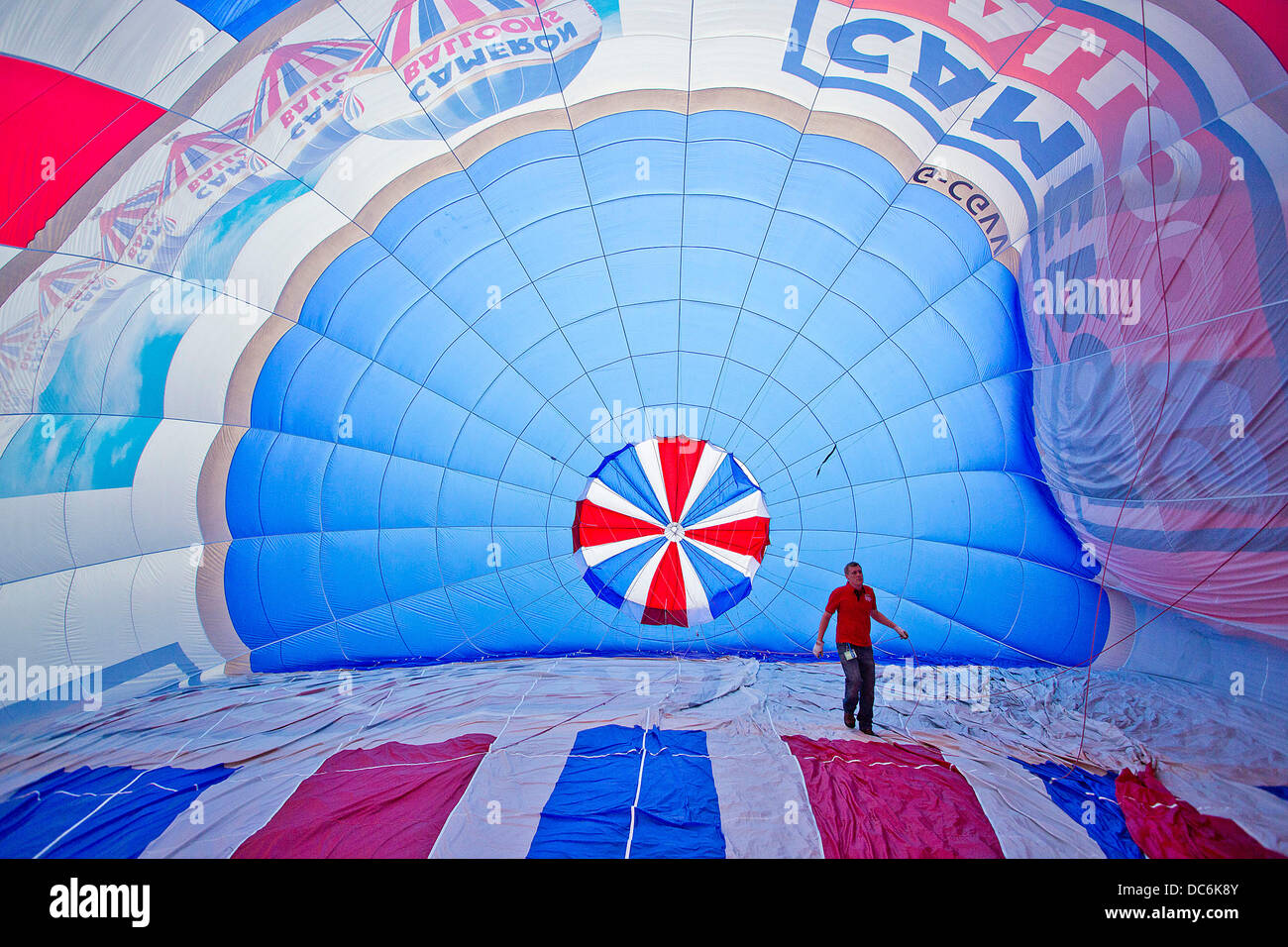 Bristol, UK. 10th August 2013. A crew member prepares a balloon before ...